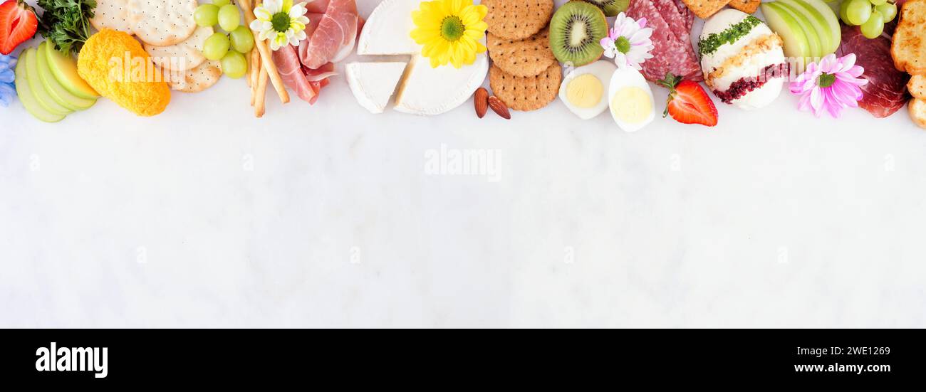 Spring or Easter charcuterie top border against a white marble banner ...