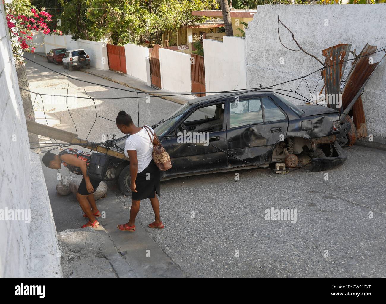 People walk past a barricade built by residents to protect their ...