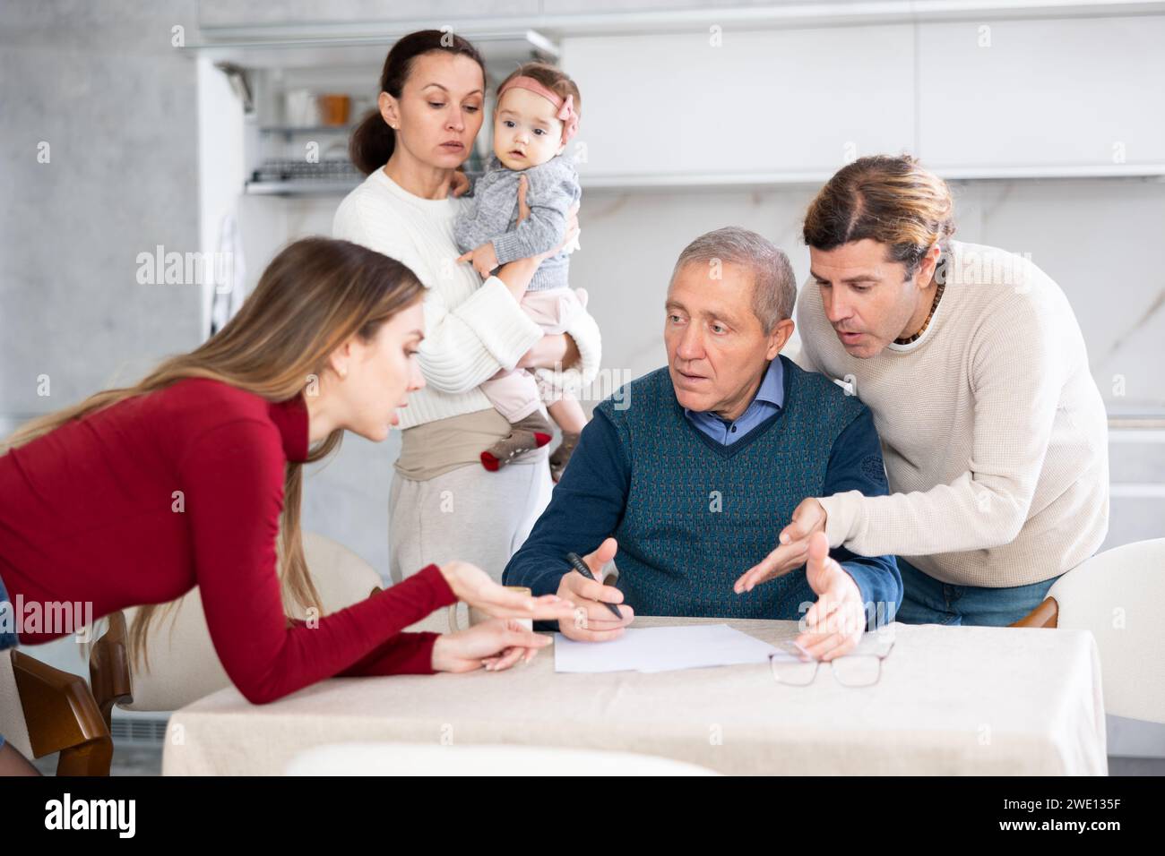 Family of different ages arguing while filling out important documents ...