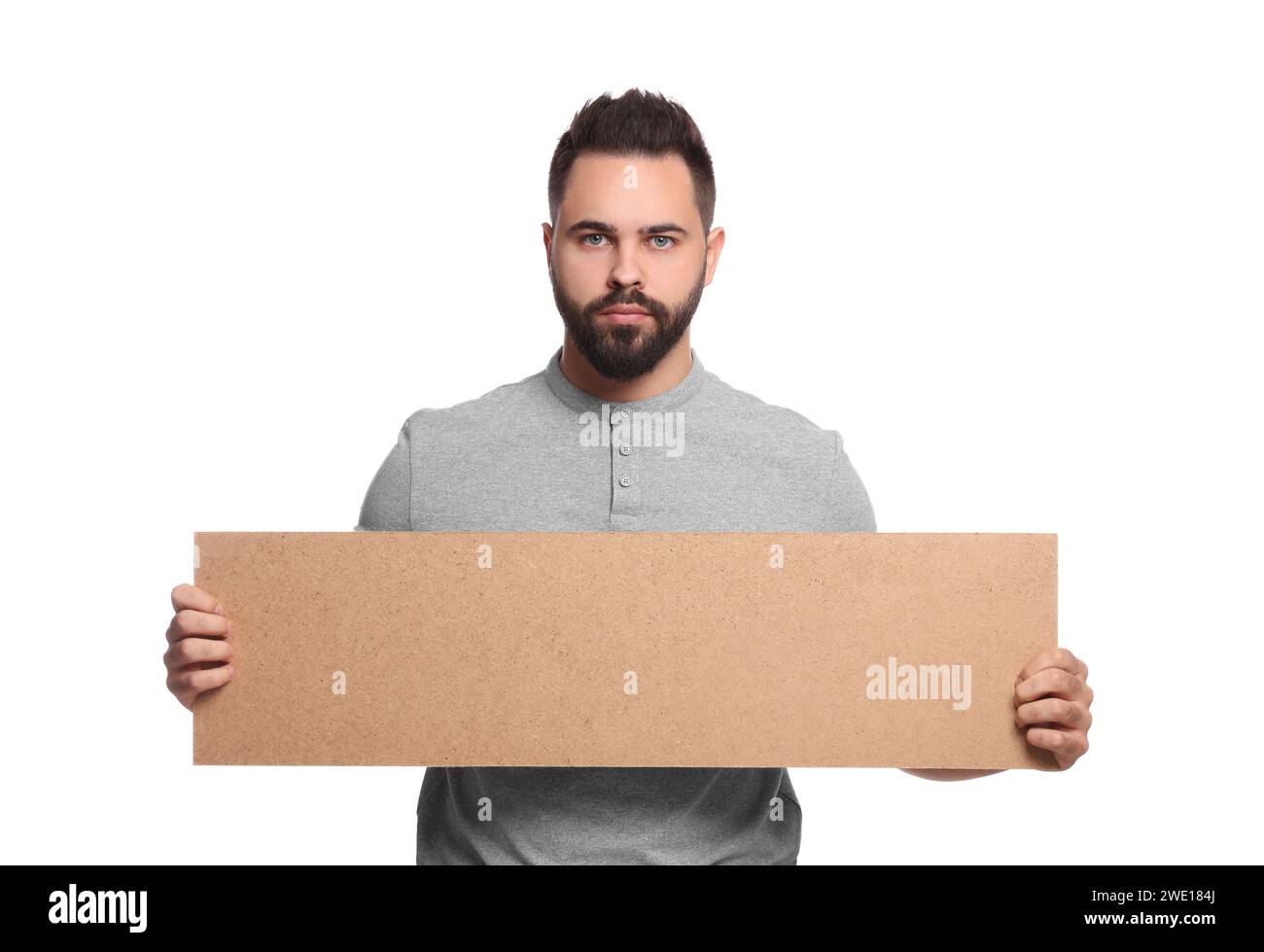 Young man holding blank cardboard banner on white background, space for ...