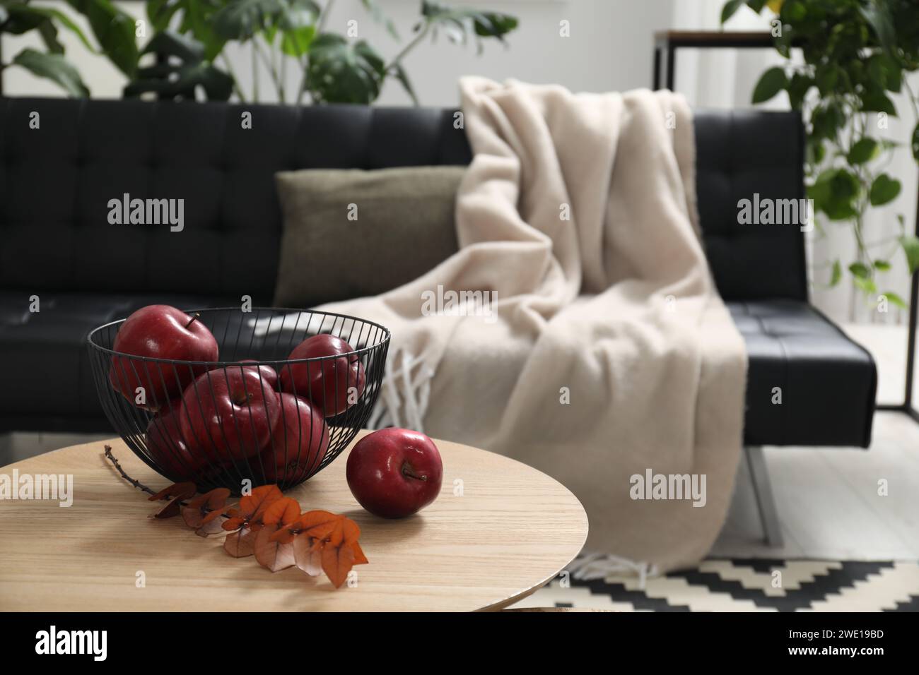 Red apples and dry eucalyptus branch on side table in room, space for ...