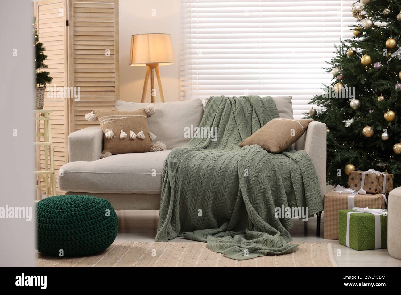 Sofa near Christmas tree in room. Festive interior design Stock Photo ...