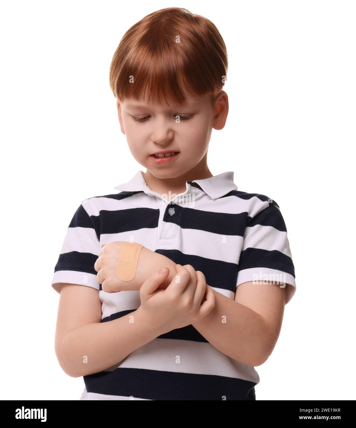 Little boy with sticking plaster on hand against light blue background ...