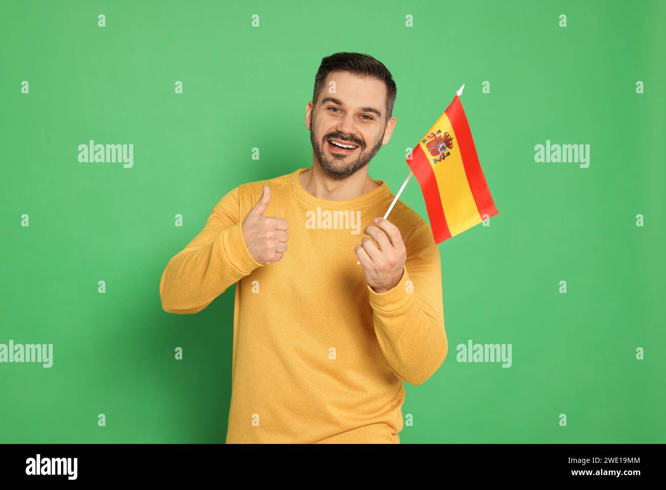 Man with flag of Spain showing thumb up on green background Stock Photo ...