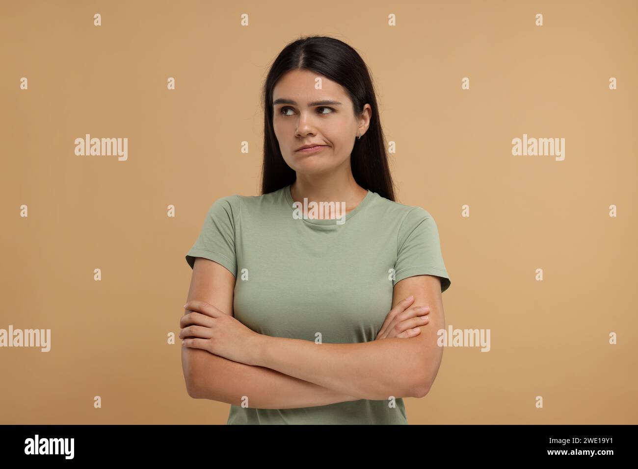 Portrait of resentful woman with crossed arms on beige background Stock ...