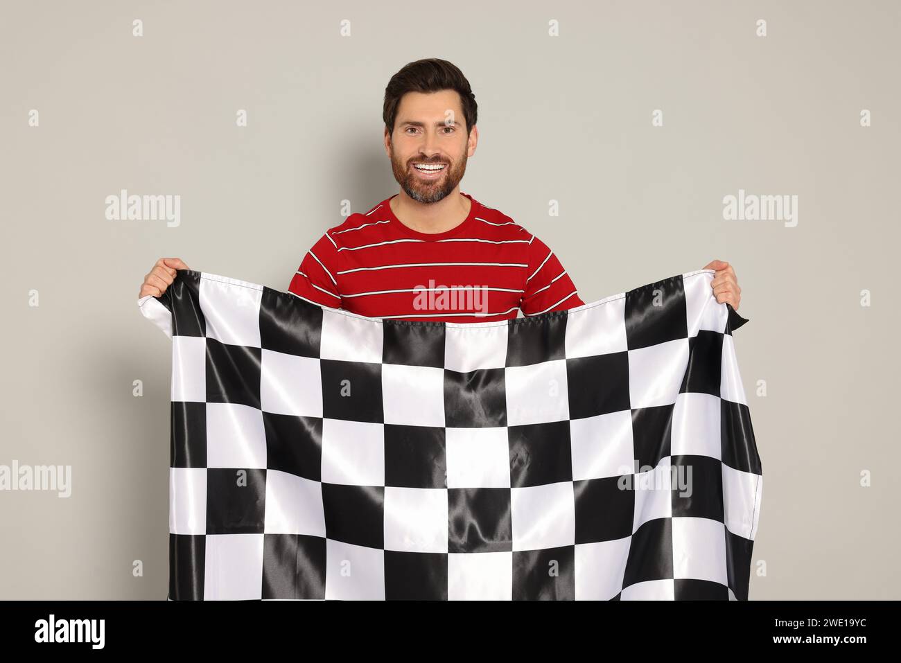 Man with checkered flag on white background Stock Photo - Alamy