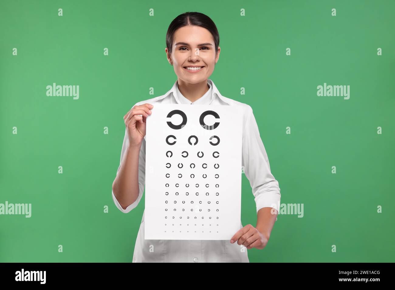 Ophthalmologist with vision test chart on green background Stock Photo ...