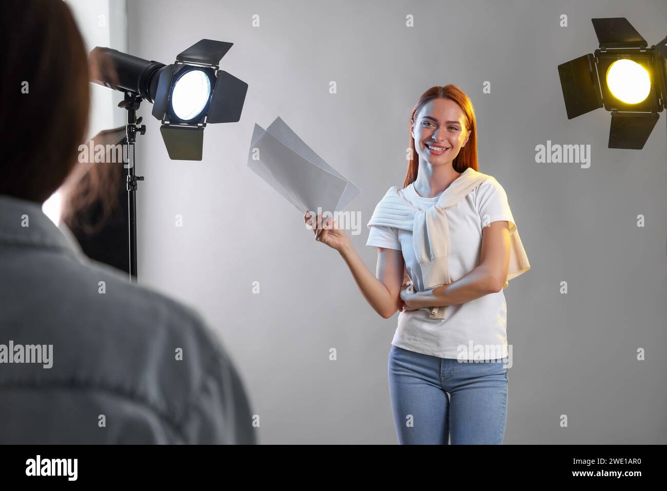 Young woman with script in front of casting director against grey ...