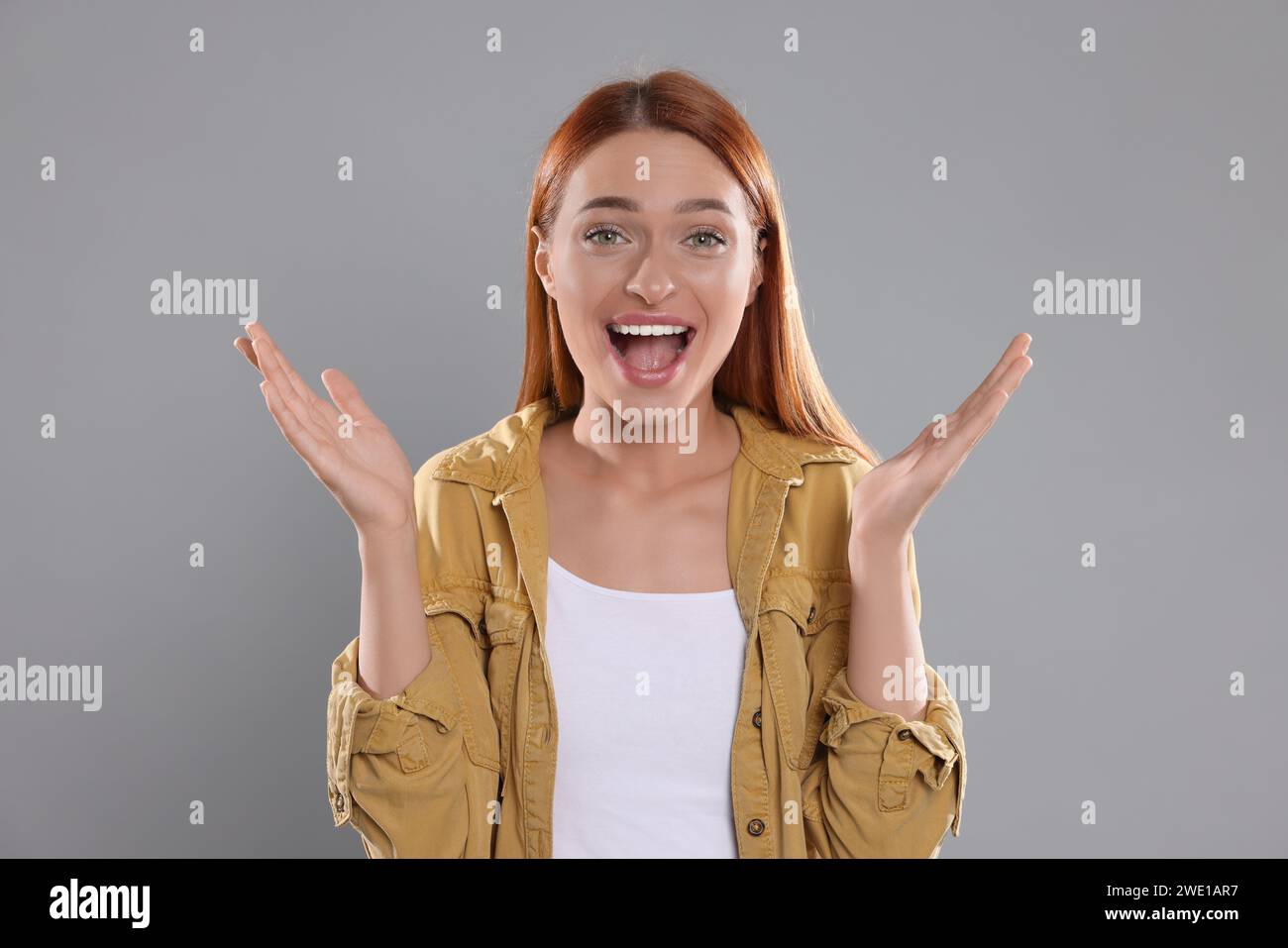 Casting call. Emotional woman performing on grey background Stock Photo ...