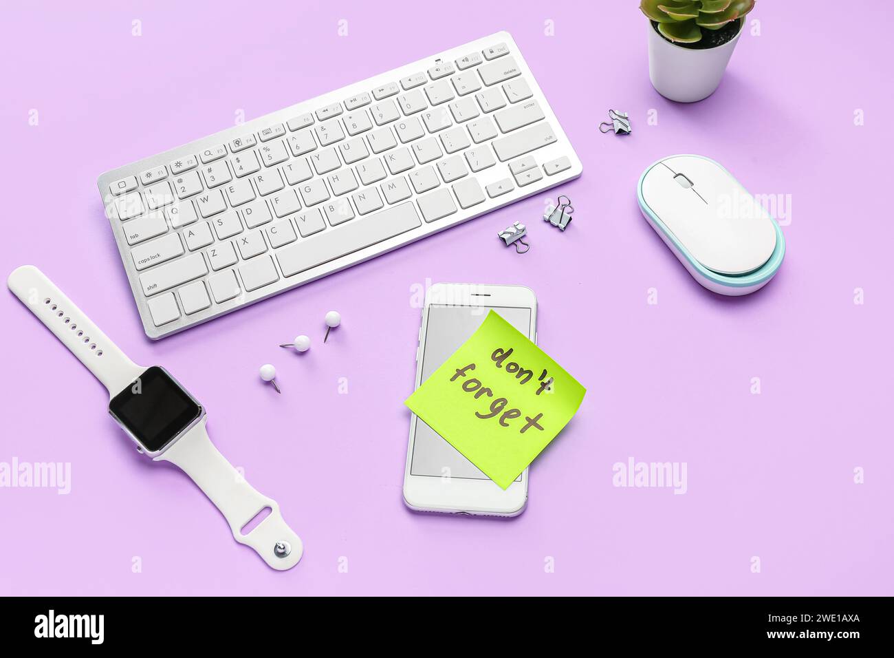 Sticky note with text DON'T FORGET, gadgets and paperclips on lilac ...