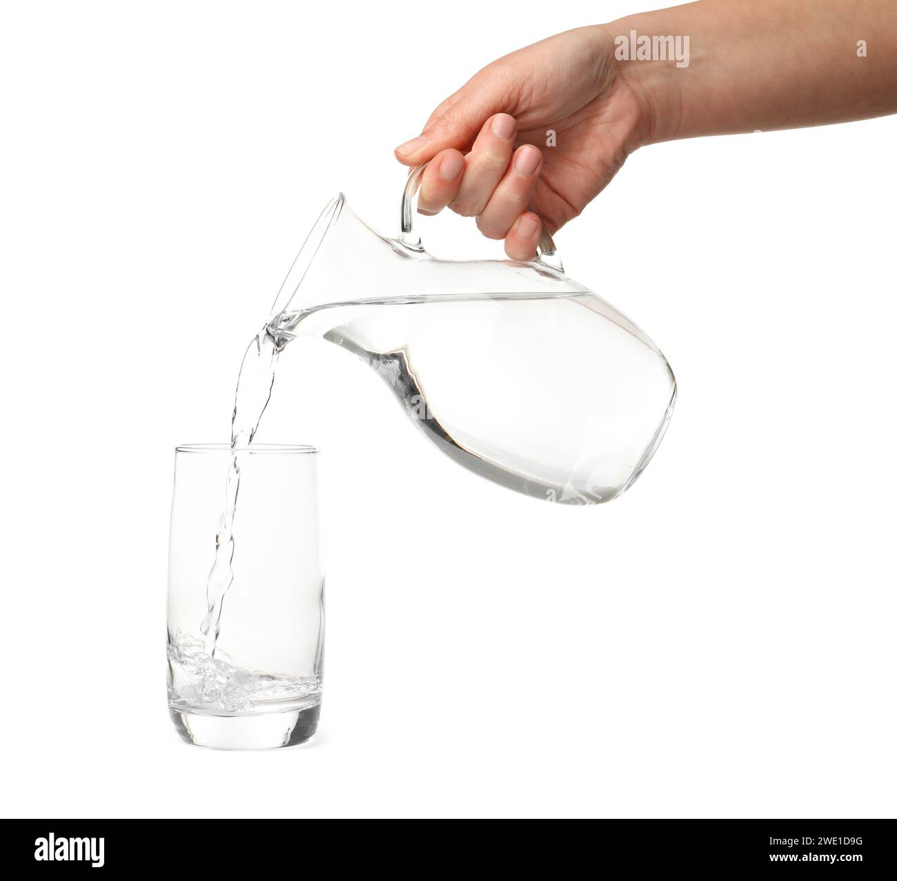 Woman pouring water from jug into glass on white background, closeup ...