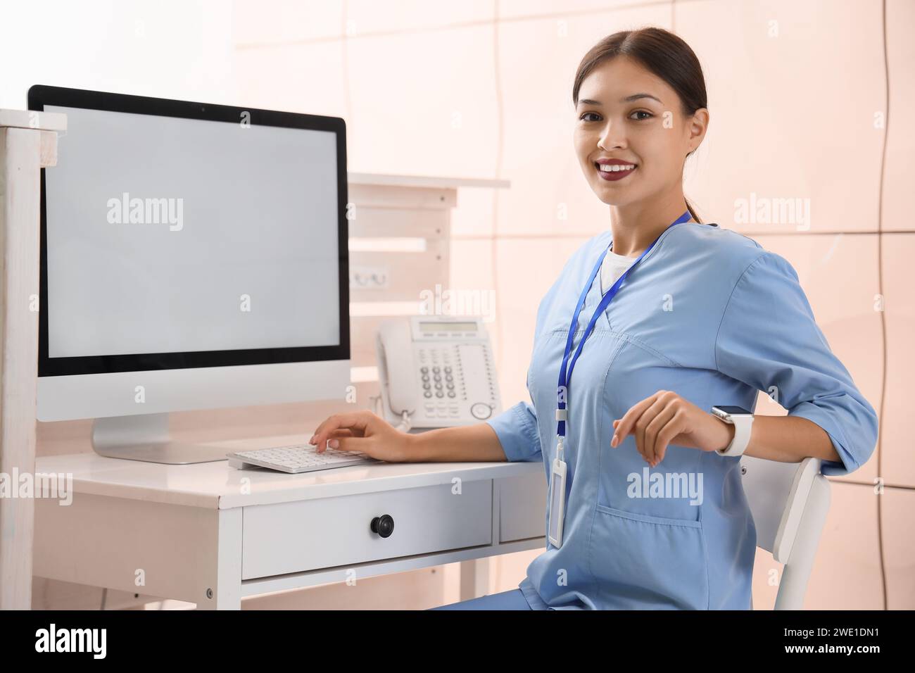 Female Asian medical intern at reception in clinic Stock Photo - Alamy