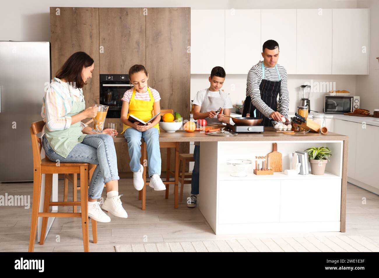 Happy family cooking in kitchen Stock Photo - Alamy