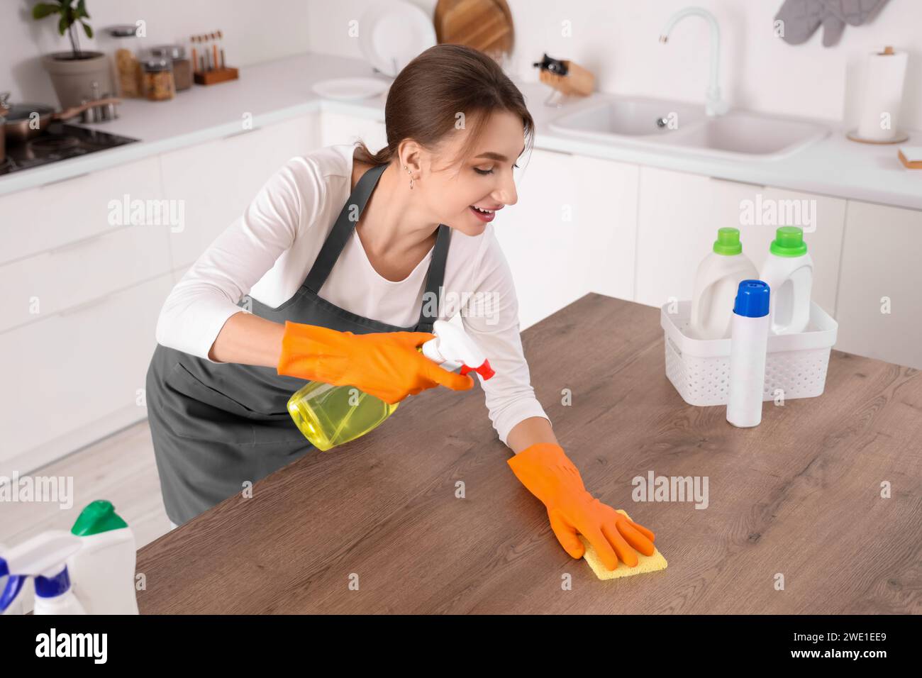 Female janitor cleaning table in kitchen Stock Photo - Alamy