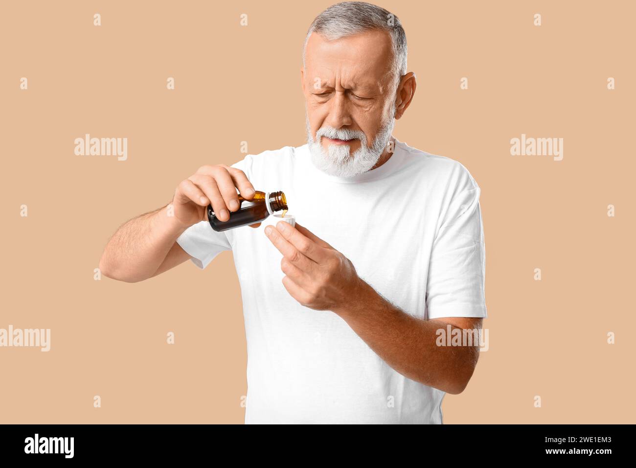 Old man with sore throat holding cough syrup on beige background Stock ...