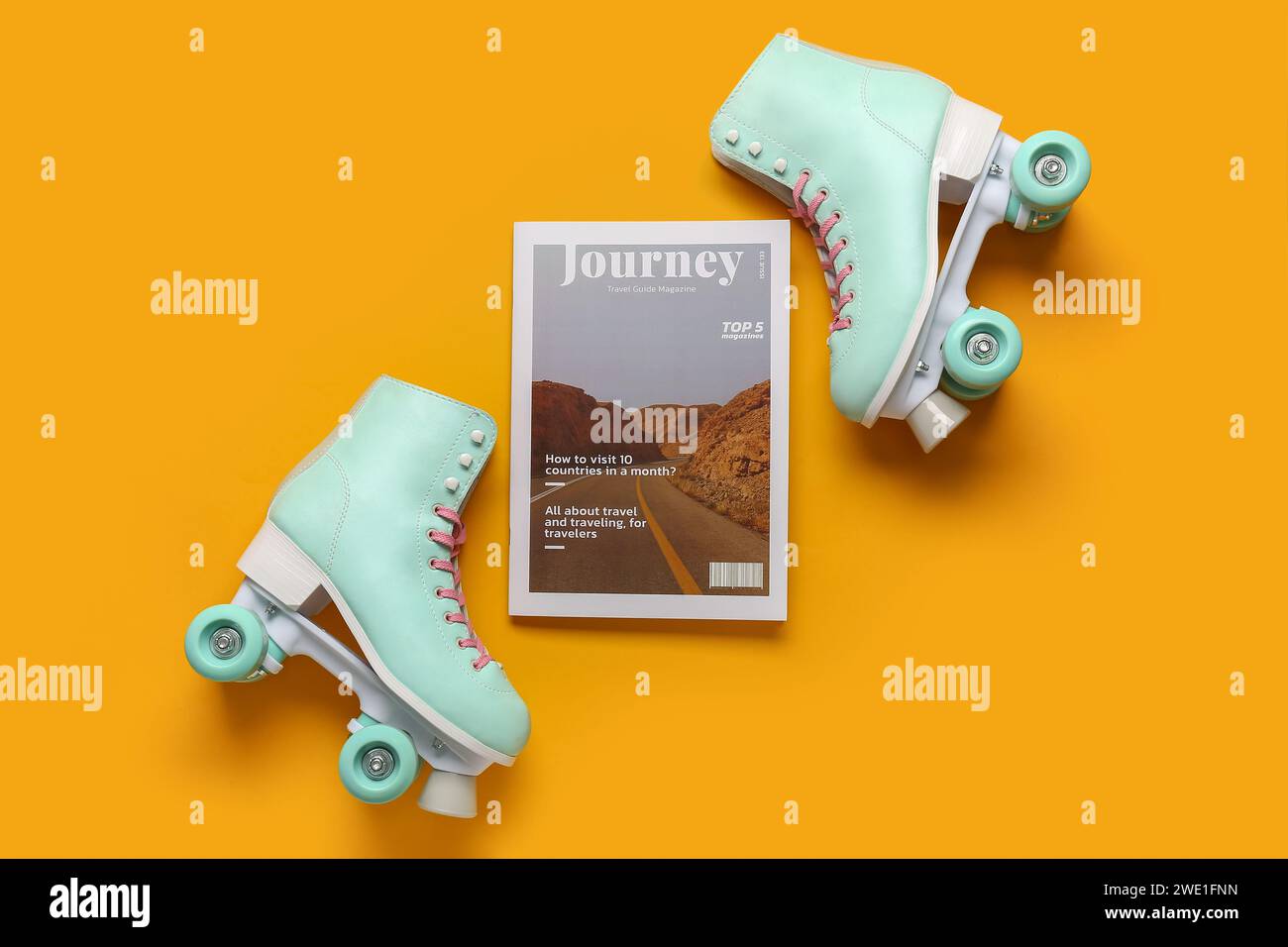 Composition with pair of vintage roller skates and magazine on orange ...