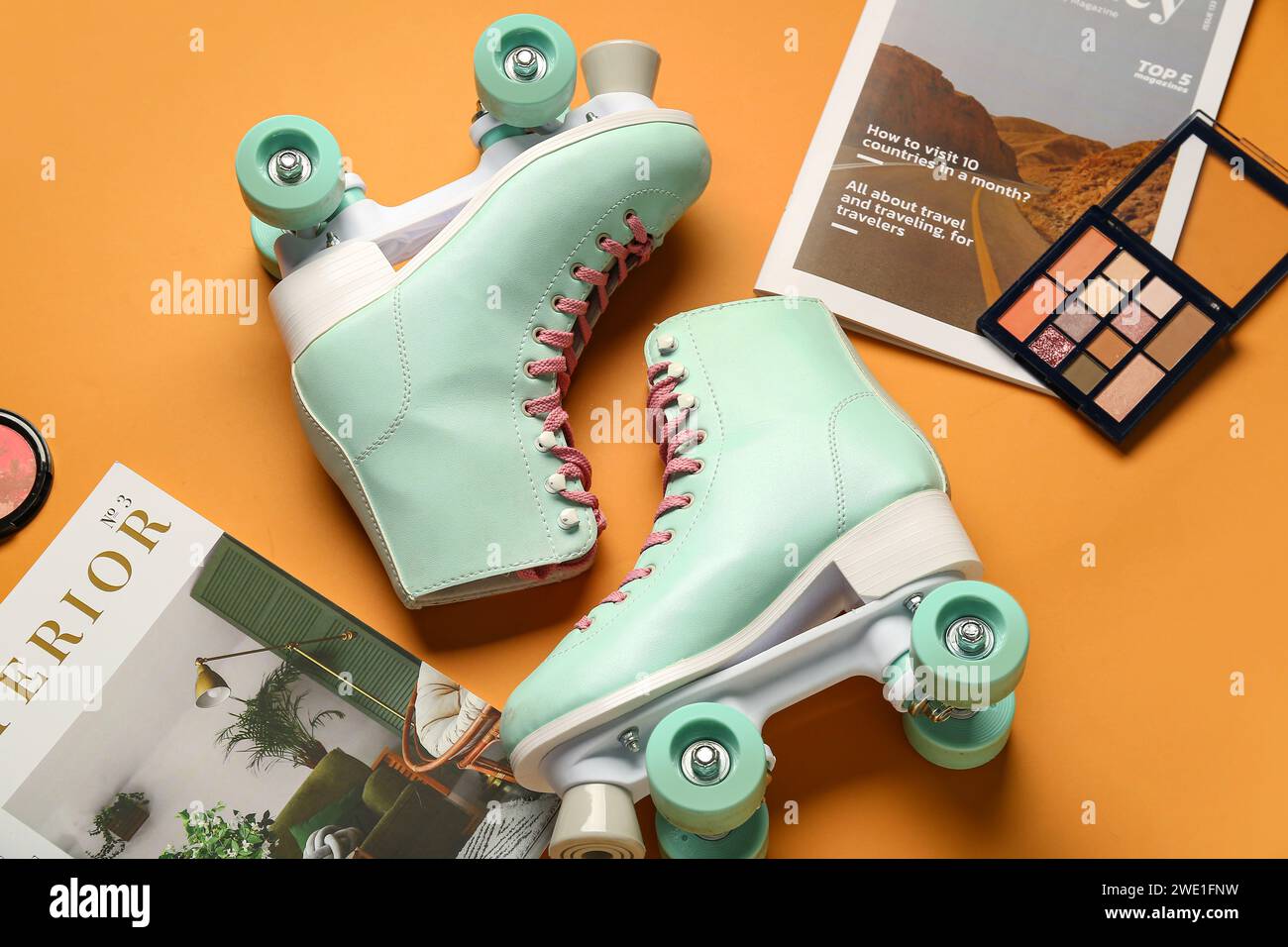 Composition with pair of vintage roller skates, magazines and cosmetic ...