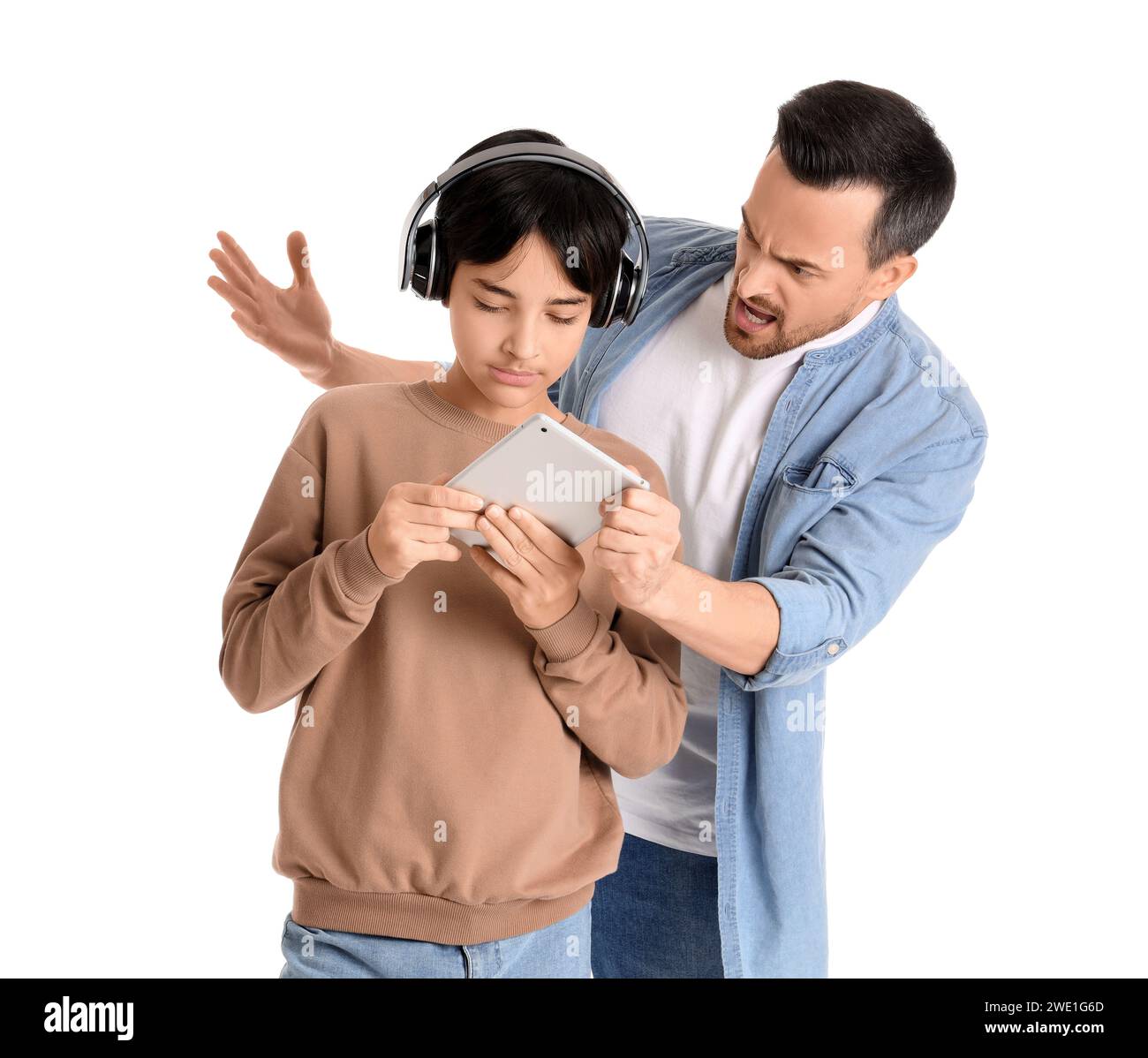 Angry father taking tablet computer away from his teenage son on white ...