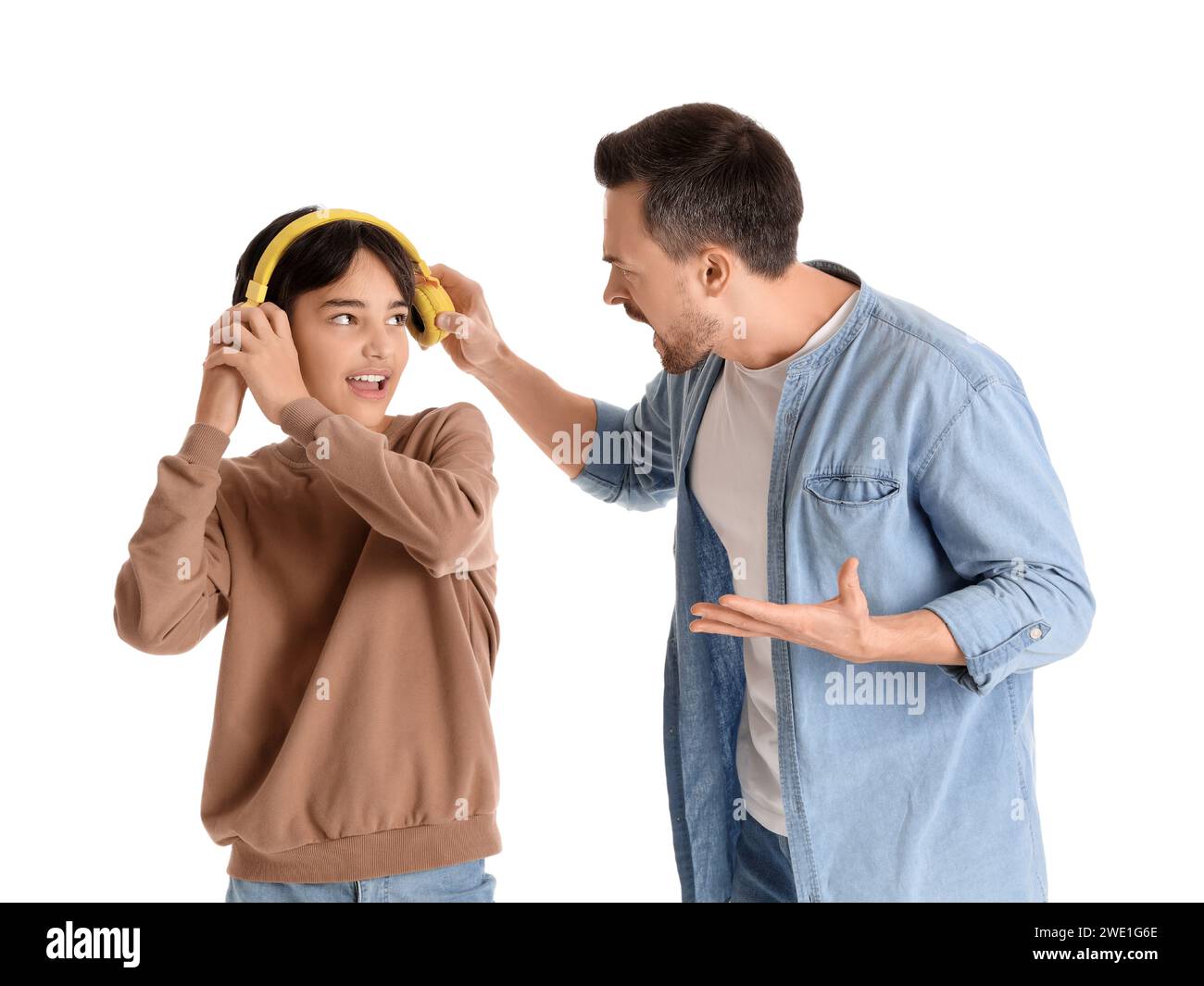 Angry father shouting at his teenage son in headphones on white ...
