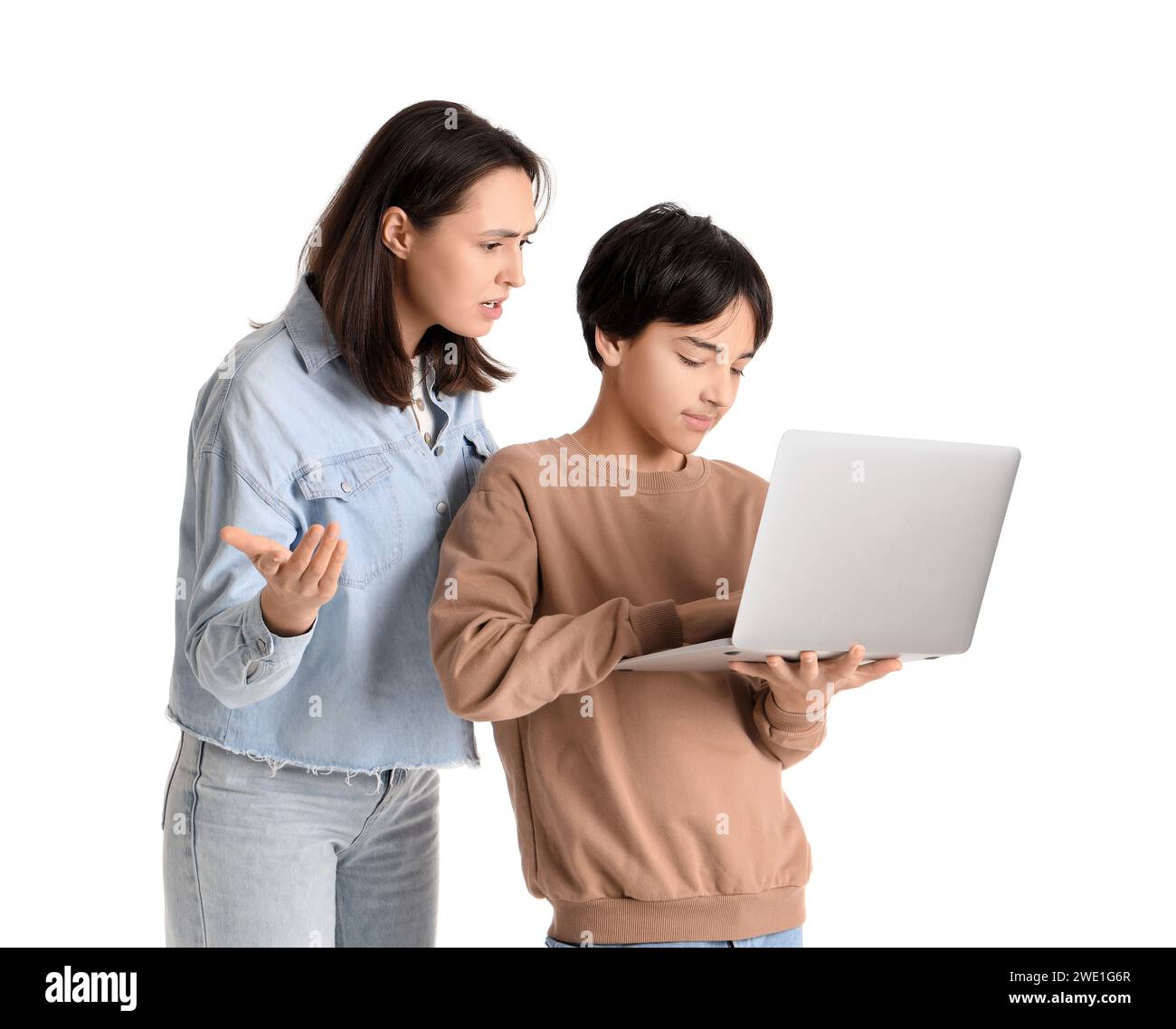 Teenage boy using laptop and his angry mother on white background ...