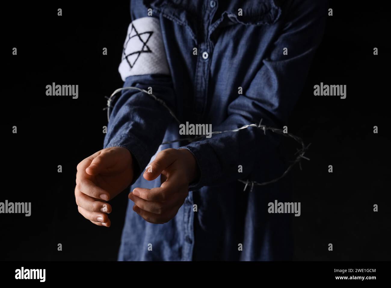 Little Jewish girl with barbed wire on black background, closeup ...