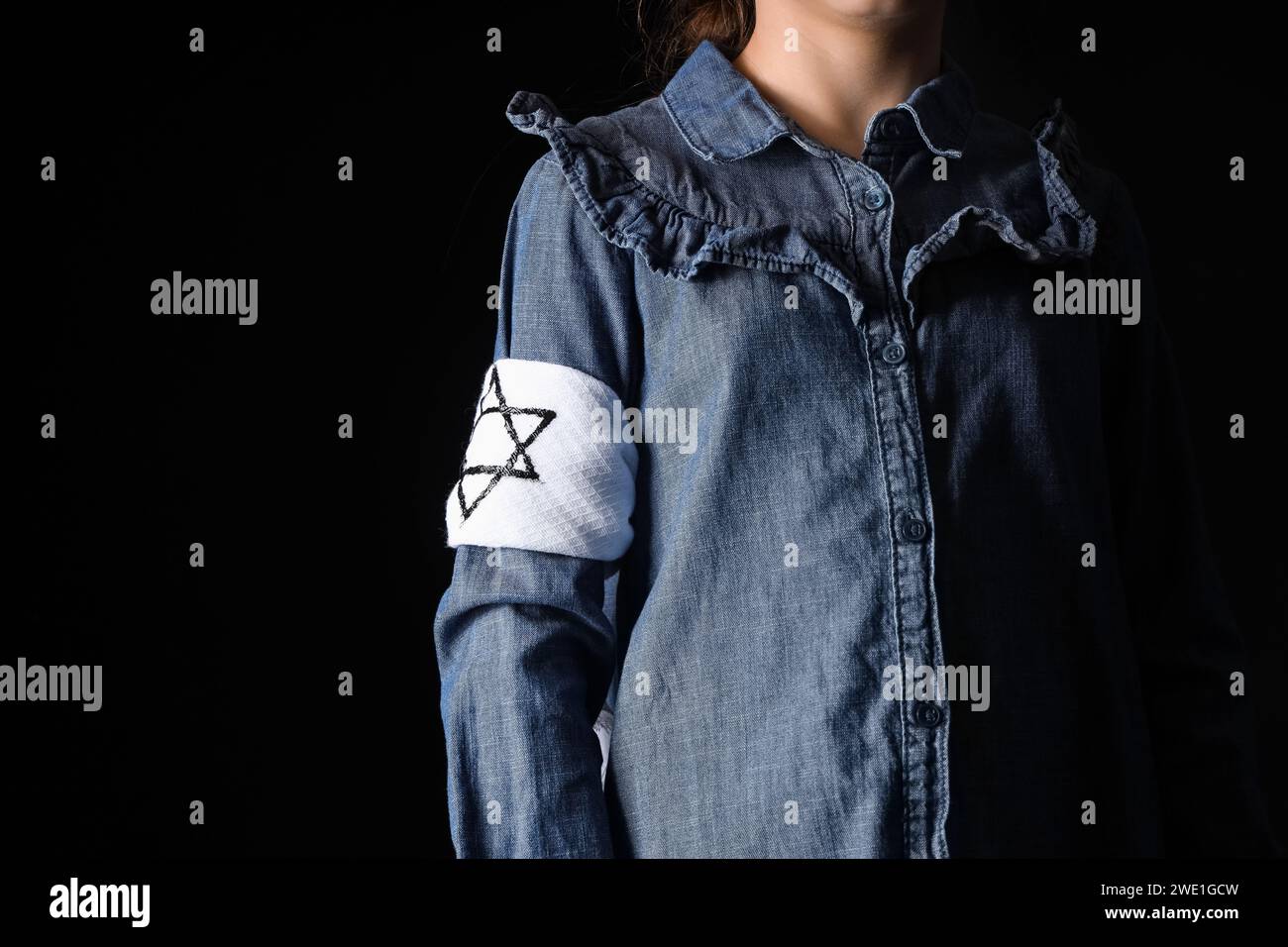 Little Jewish girl with armband on black background, closeup ...