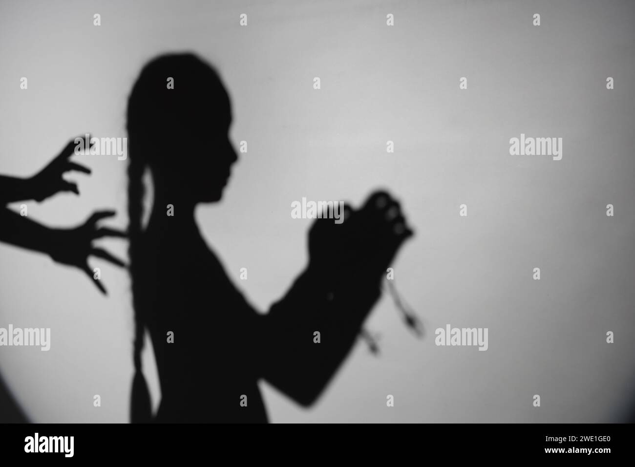 Shadow of little Jewish girl with barbed wire and hands on light ...