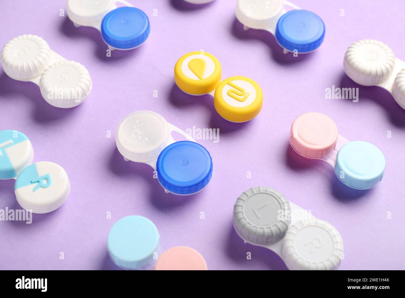 Containers for contact lenses on lilac background Stock Photo - Alamy