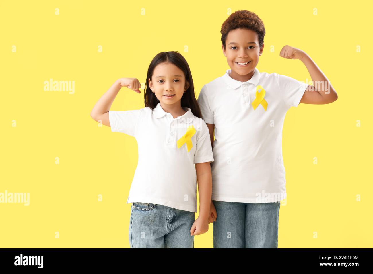 Cute little children with yellow ribbons showing muscles on color ...