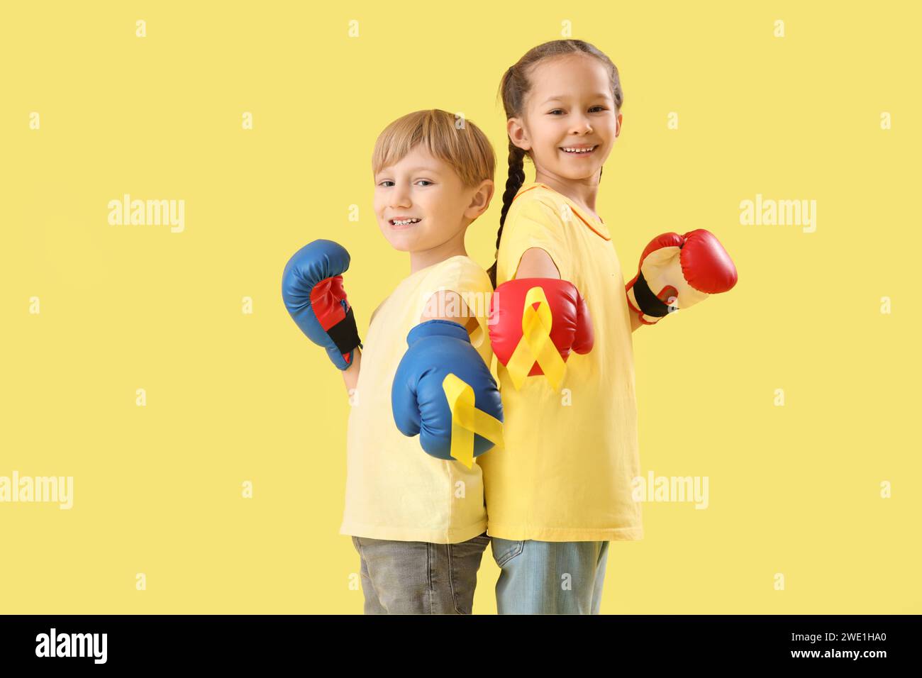 Cute little children in boxing gloves with yellow ribbons on color ...