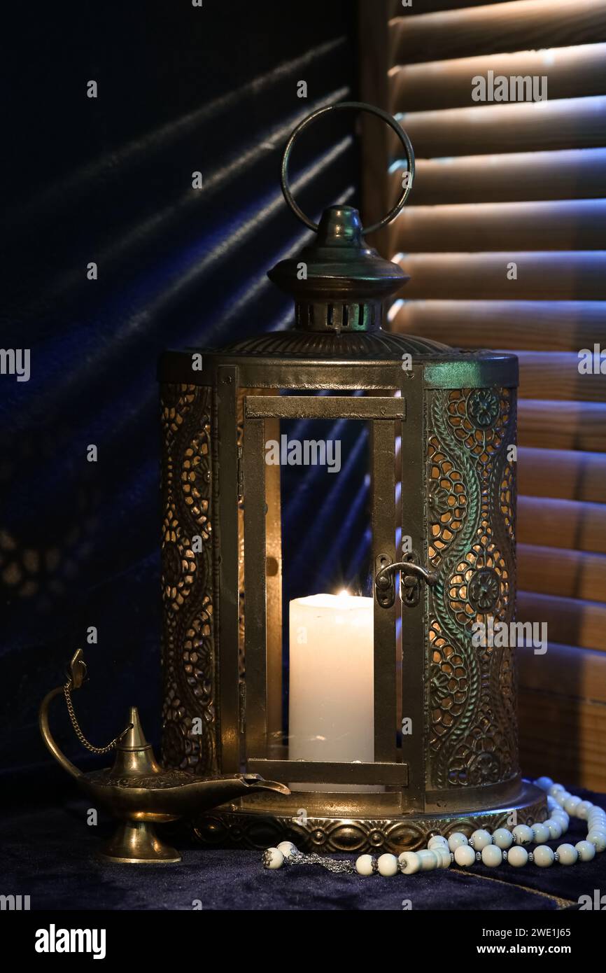 Muslim lantern with prayer beads and Aladdin lamp for Ramadan on table ...