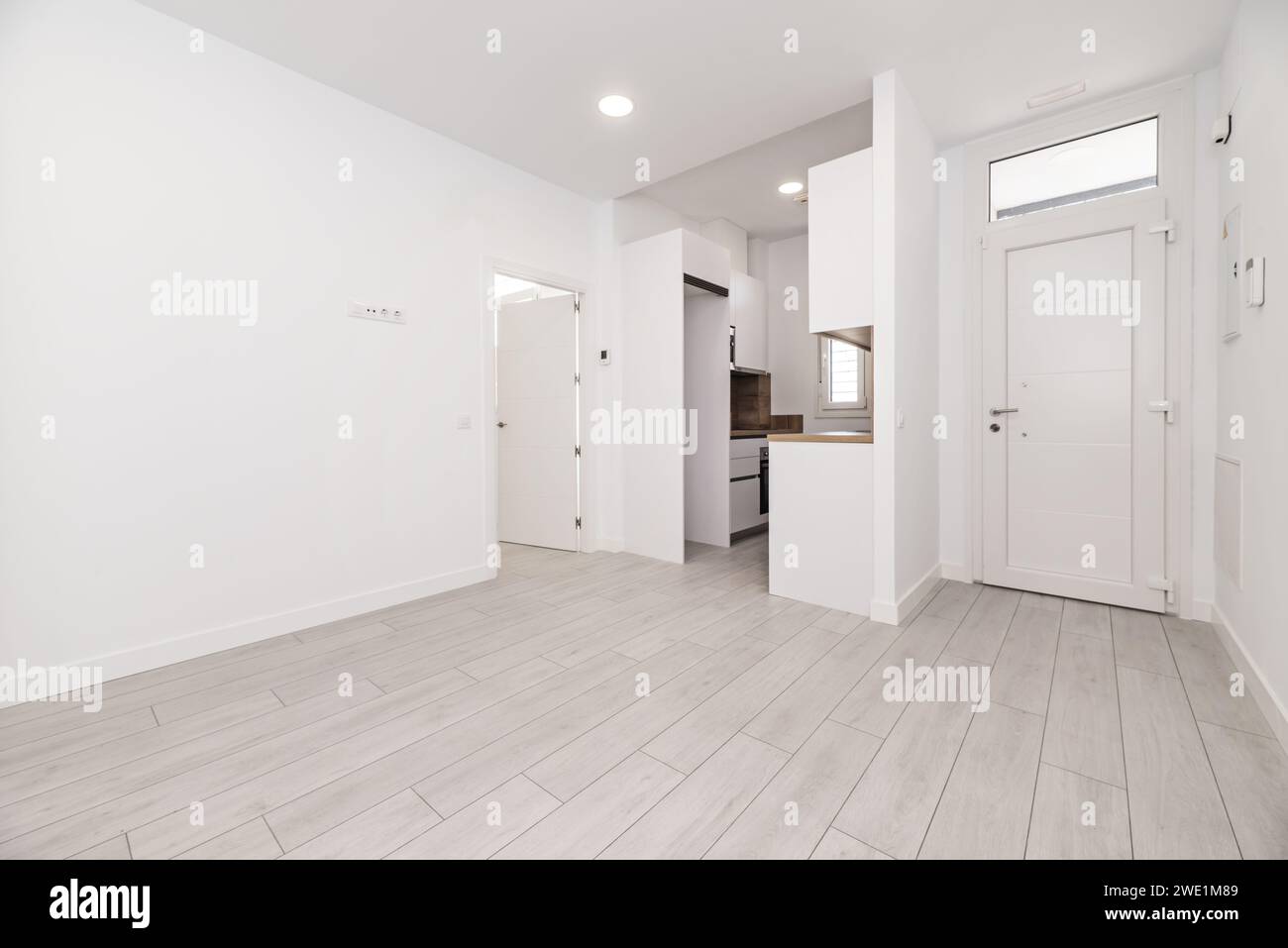 An empty white room in a loft-style house with an armored access door ...