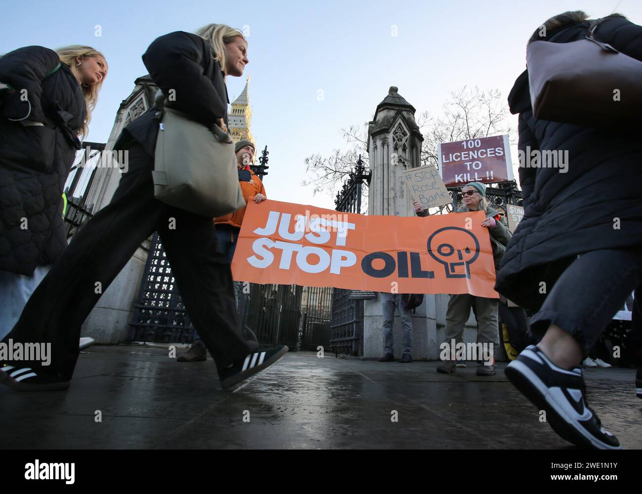 Protesters hold up placards and stand behind a "Just Stop Oil" banner ...