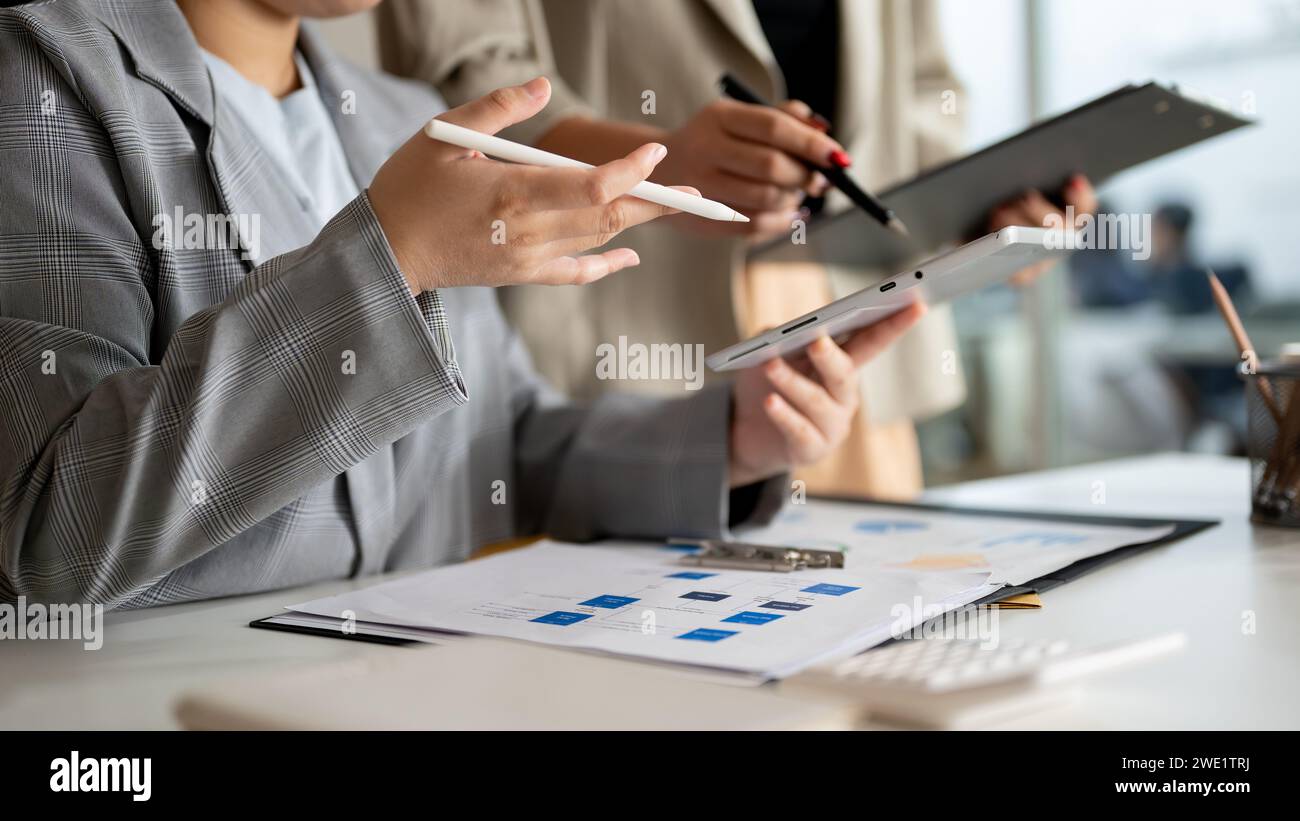 Two focused businesswomen or female accountants are brainstorming and ...