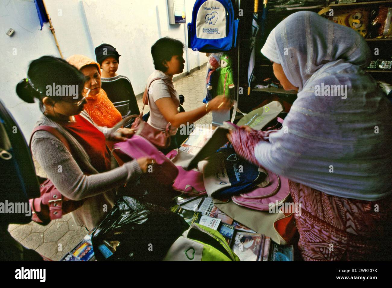 Women are choosing merchandise at a streetside shop near the house of ...