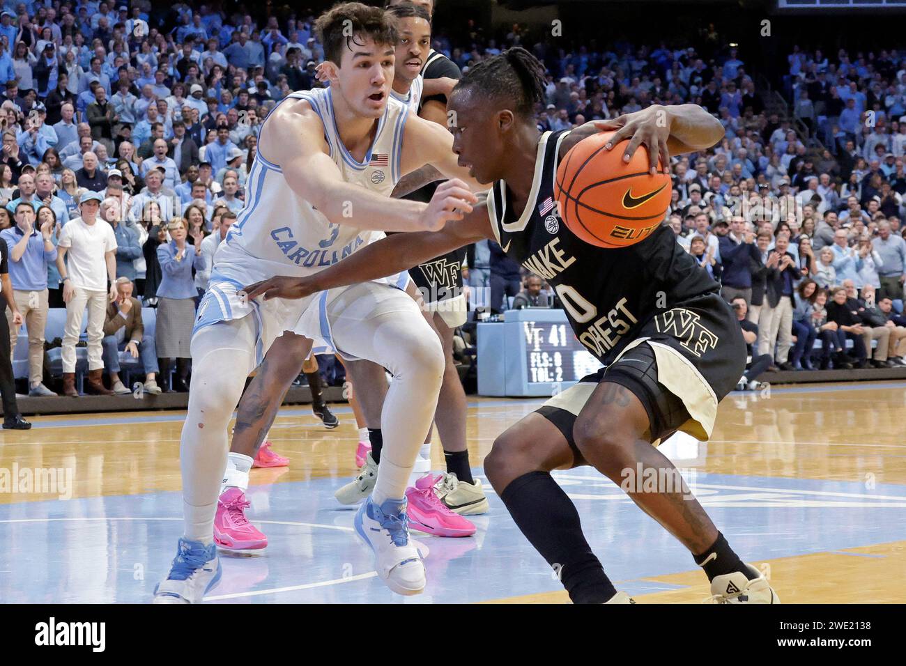 Wake Forest guard Kevin Miller is defended by North Carolina guard ...