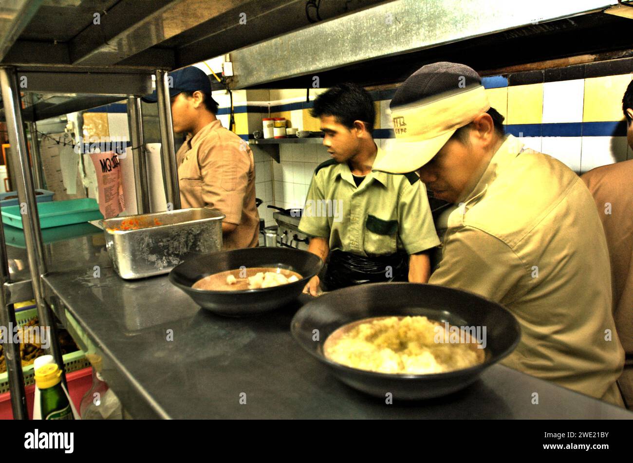Chefs prepare halal foods at the kitchen of an Islamic cafe managed by ...