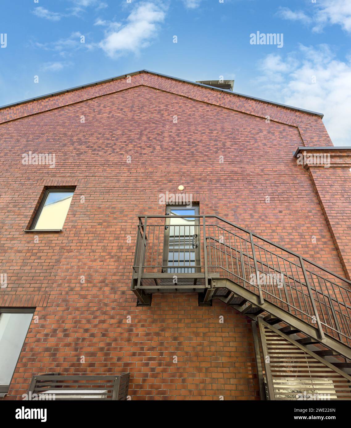 metal staircase on red brick wall of renovated building. fire escape on ...