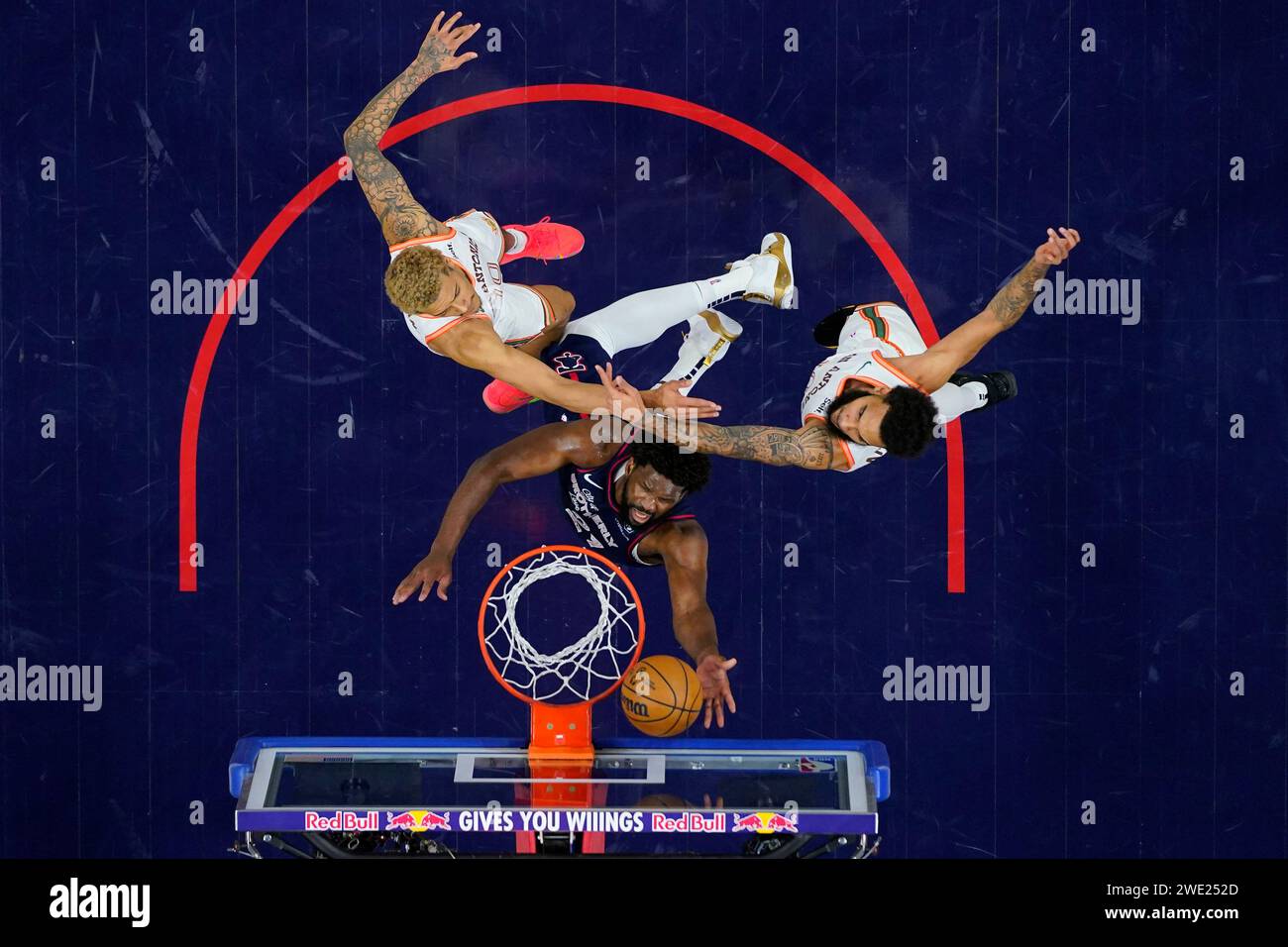Philadelphia 76ers' Joel Embiid, center, goes up for a shot between San ...