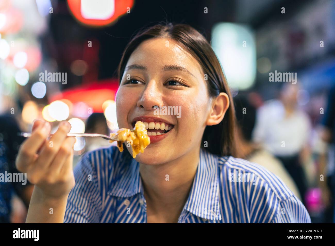 Young Asian woman traveler tourist eating Thai street food in China ...