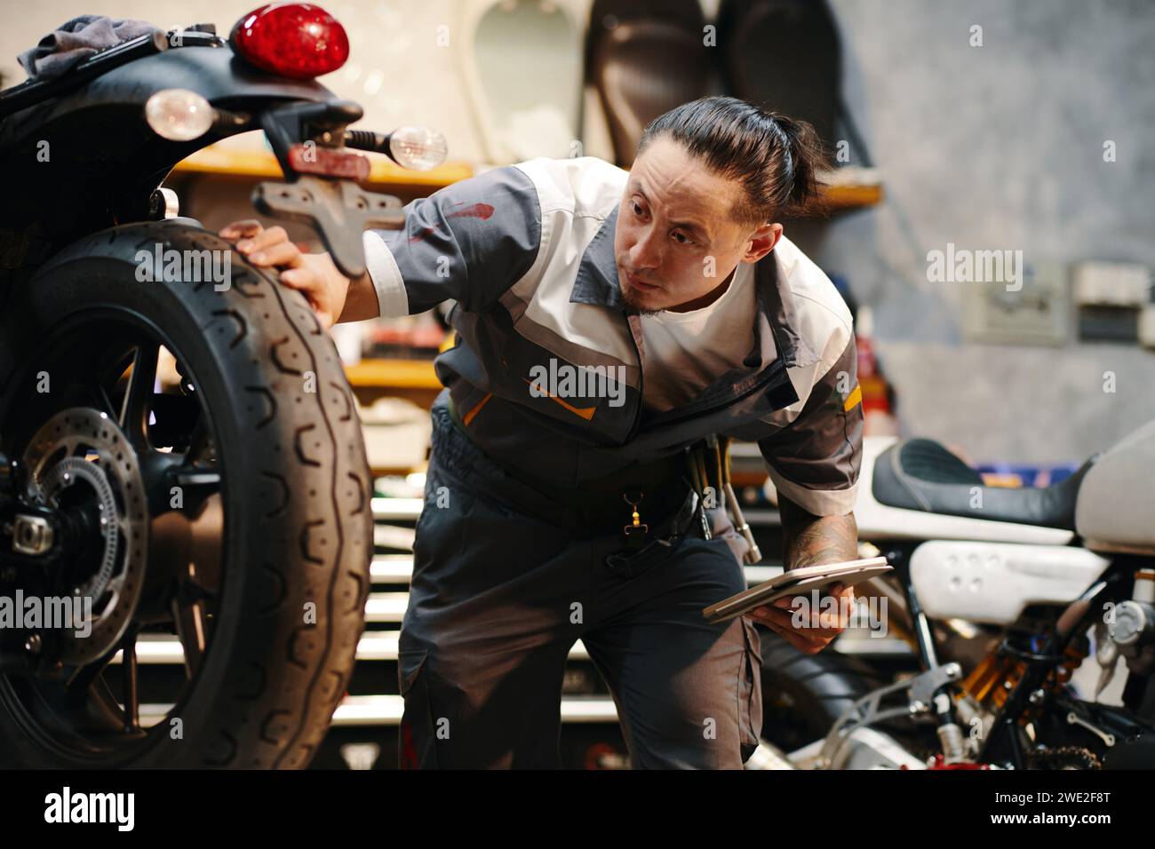 Worker checking tires in garage hi-res stock photography and images - Alamy