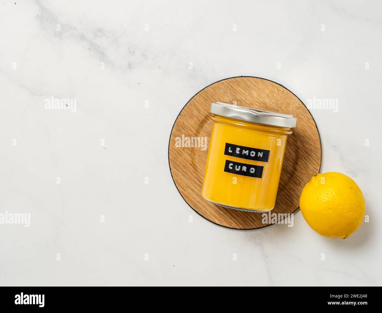 Delicious homemade lemon curd. Glass jar with lemon curd on white ...