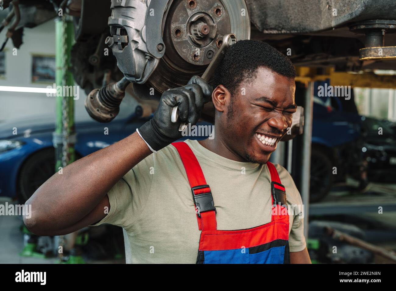 African man mechanic in uniform at the car repair station, portrait ...