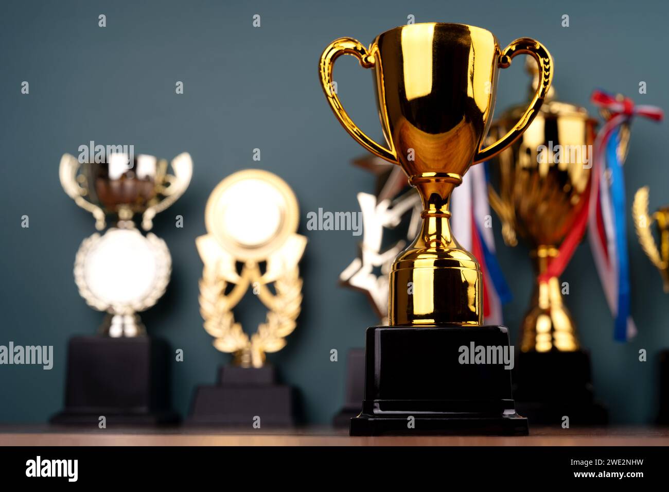 Gold Trophy with a row of gold trophy background Stock Photo - Alamy