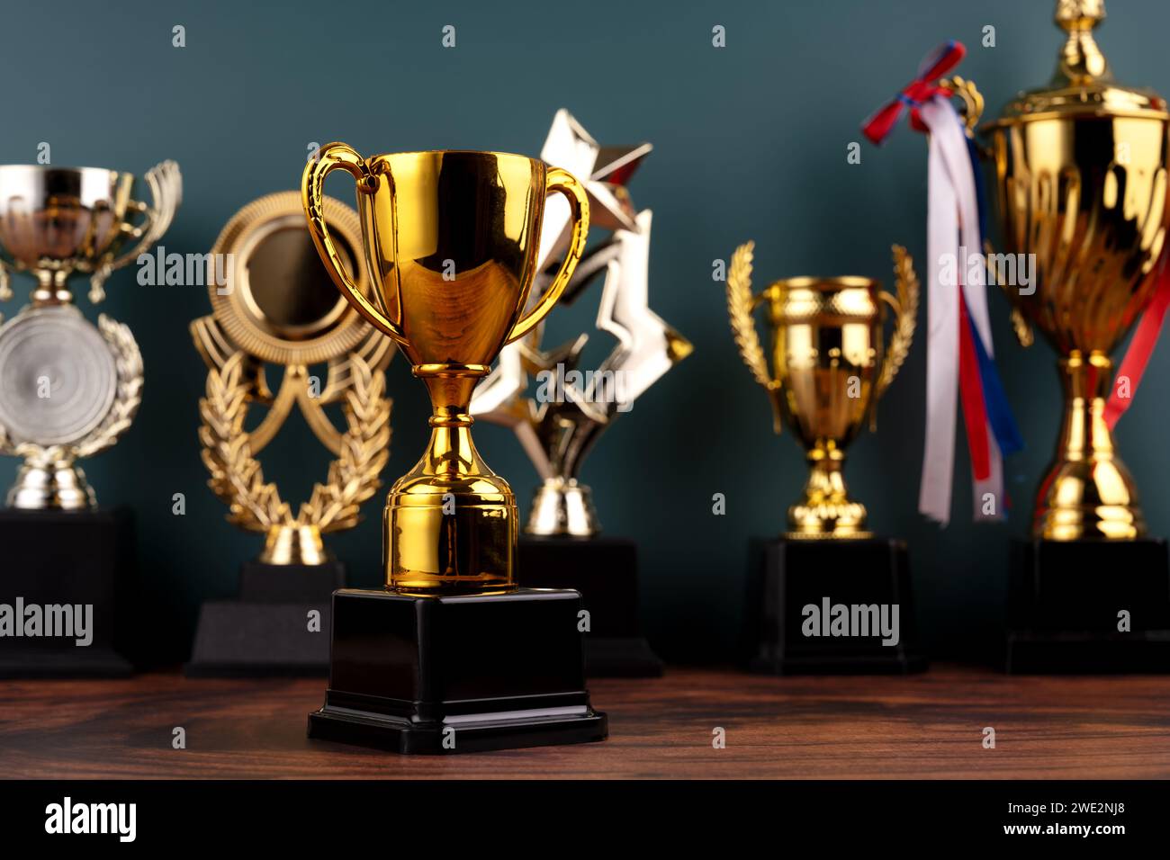 Gold Trophy with a row of gold trophy background Stock Photo - Alamy