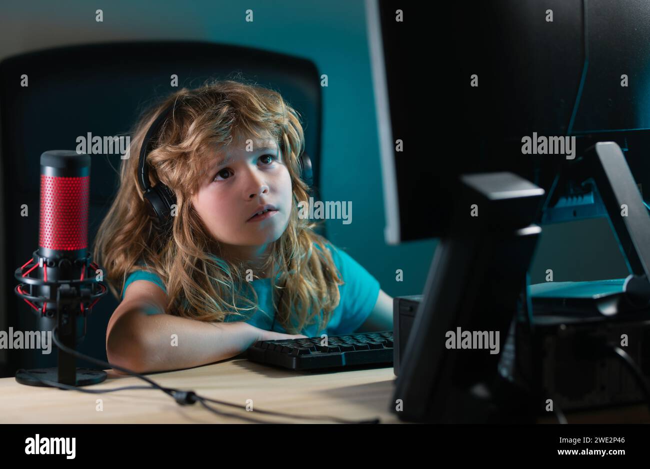 A little boy child uses a desktop at night, a child with computer ...