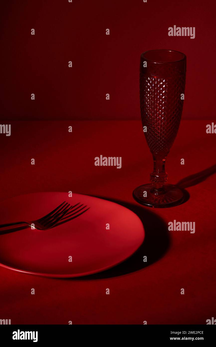 Setting of luxury dinner table with round plate, fork and glass cup on ...