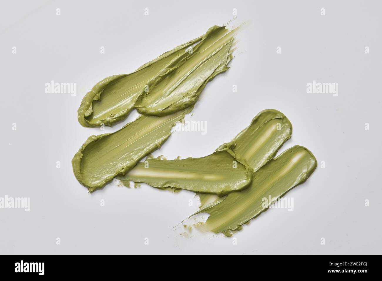 Top view of cream streaks randomly drawn on a white background with the ...