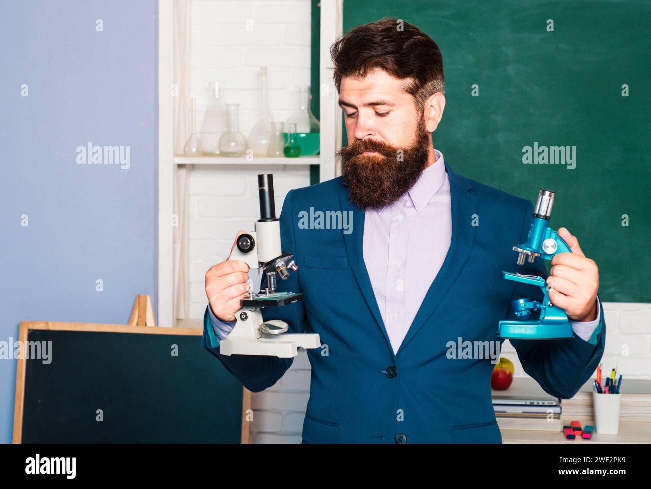 Portrait of thinking male teacher with microscope, professor, tutor ...
