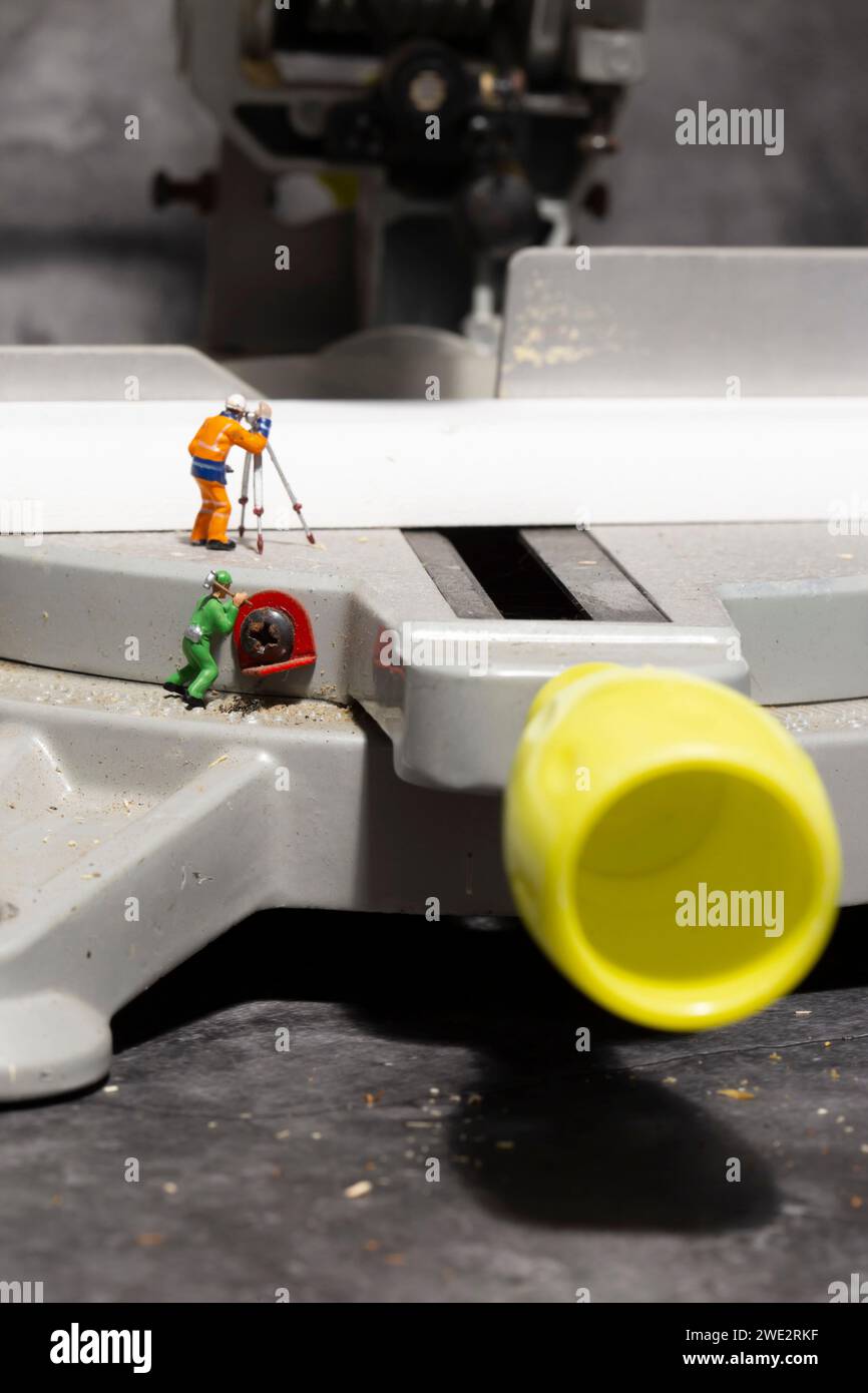 Miniature scale model workers on an electric circular saw. Construction ...